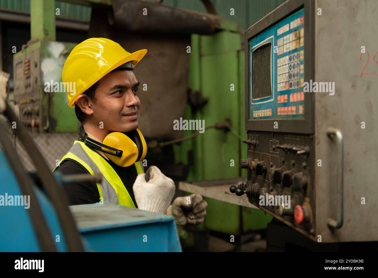 Asian mechanic working in a mechanical factory Repairing old machines ...