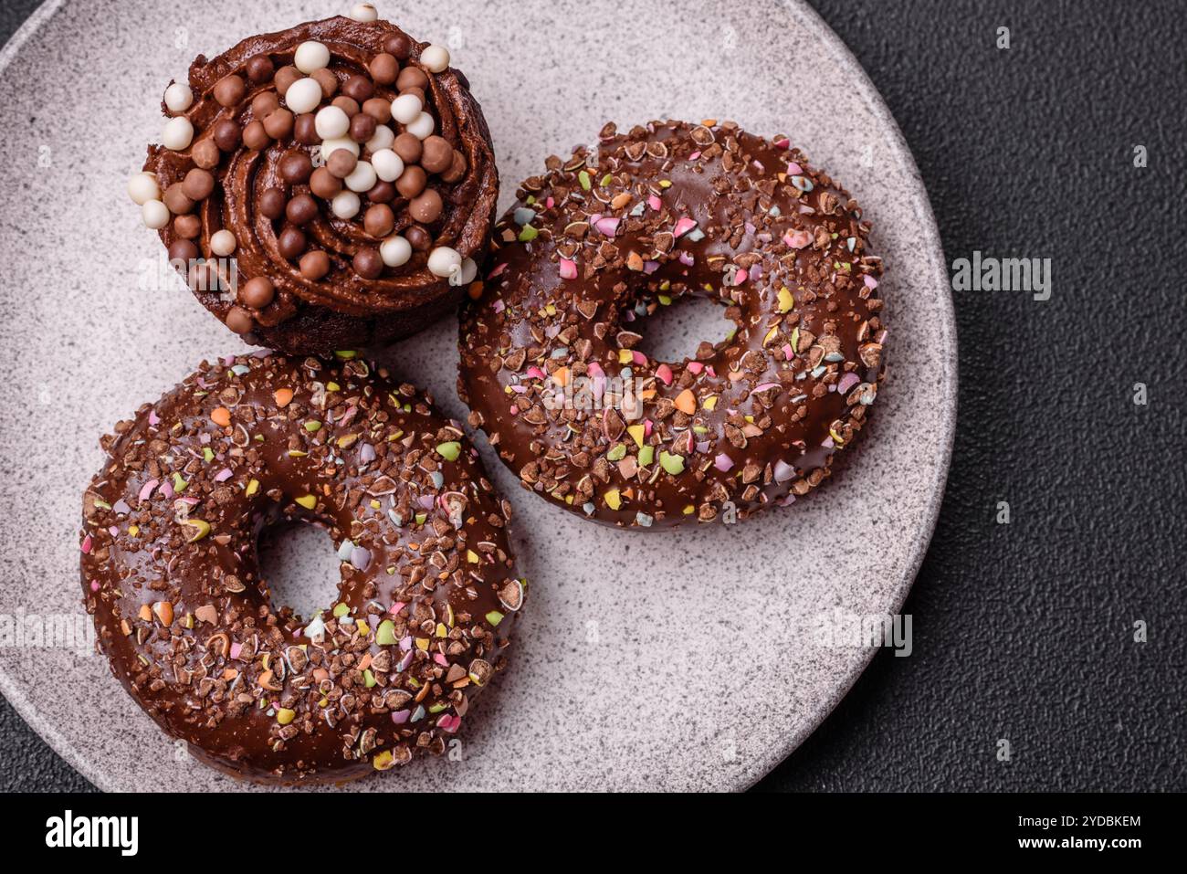 Delicious fresh donuts with filling and chocolate coating on a dark ...