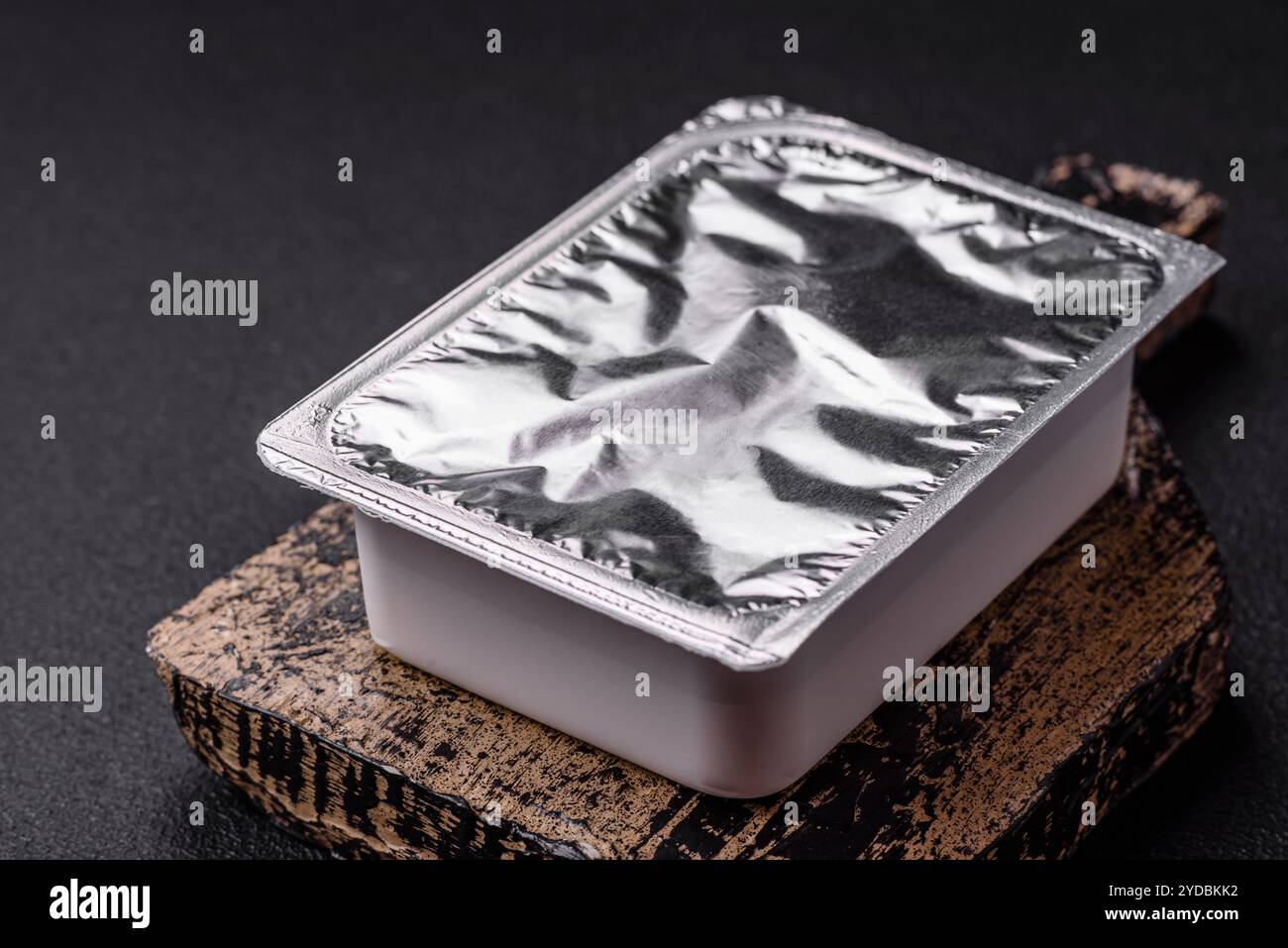 Rectangular plastic box with yogurt or cheese hermetically sealed with ...