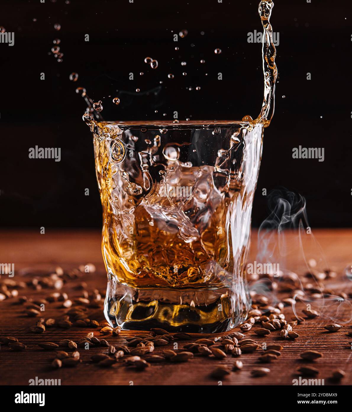 Splash of whiskey from an ice cube in glass Stock Photo - Alamy