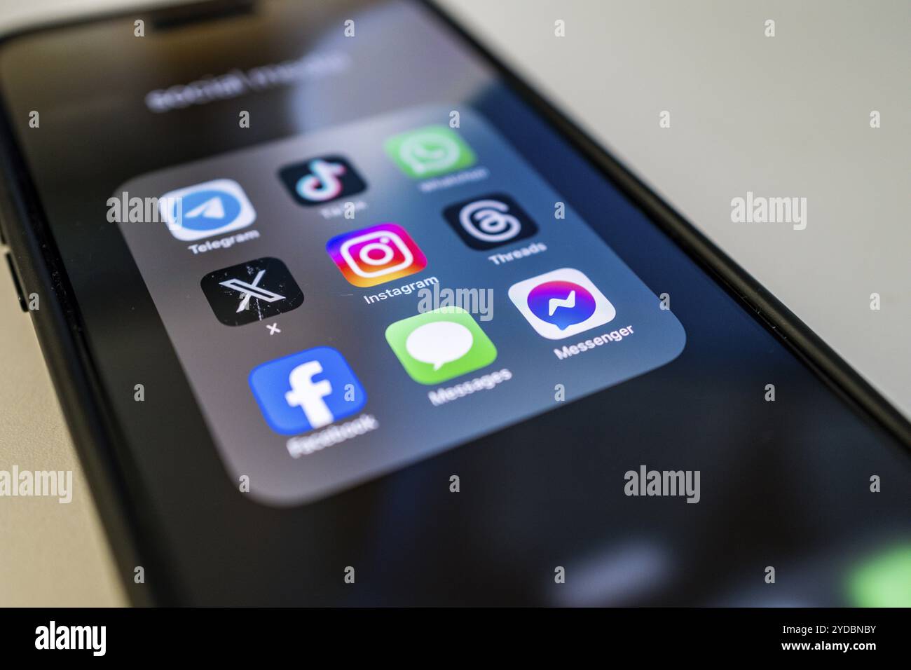 Various social media apps on a smartphone screen, blurred background ...