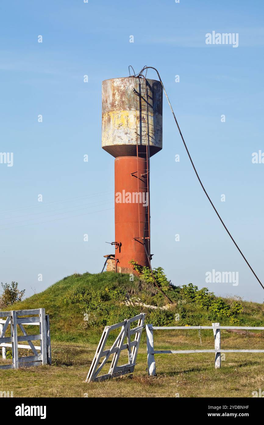 Old water tower in the countryside. A rusty, outdated water tower ...