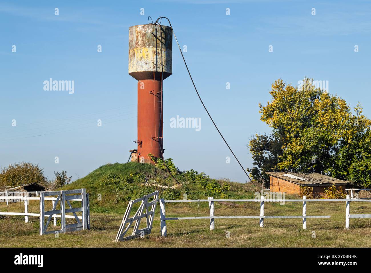 Old water tower in the countryside. A rusty, outdated water tower ...