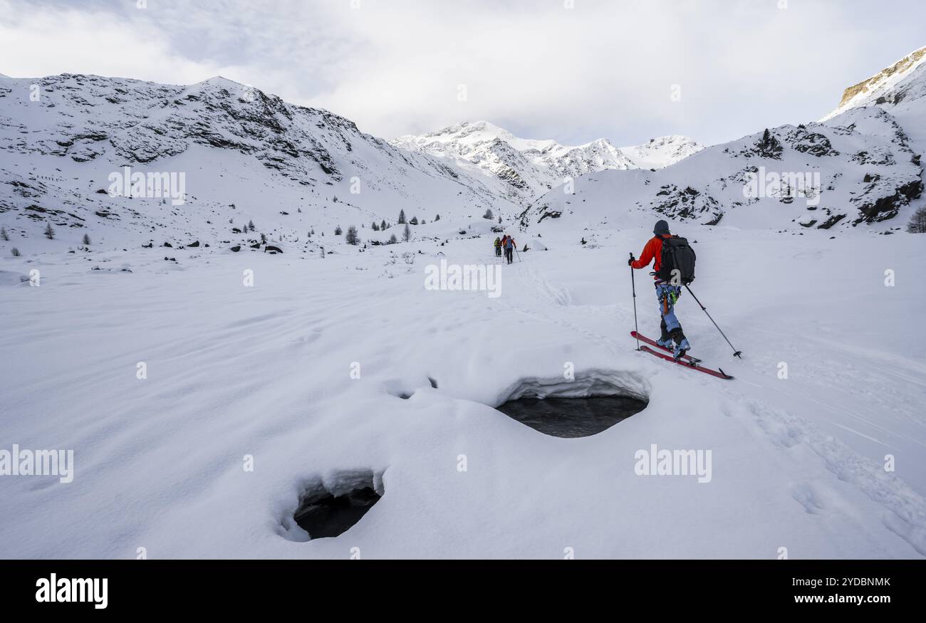 Ski tourers ascending in the rear Martell Valley, snow-covered mountain ...