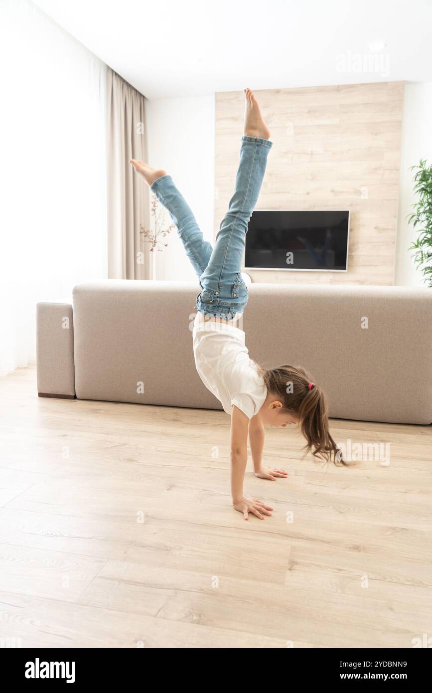 Girl walking upside down on her arms at home Stock Photo - Alamy