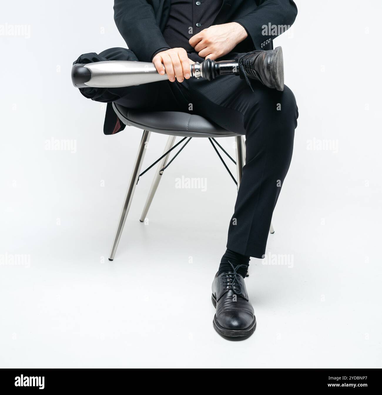 Cropped view of disabled young man with prosthetic leg sitting on a ...