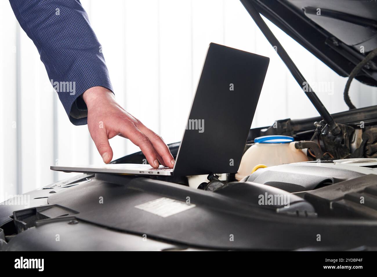 Car mechanic using computer in auto repair shop Stock Photo - Alamy
