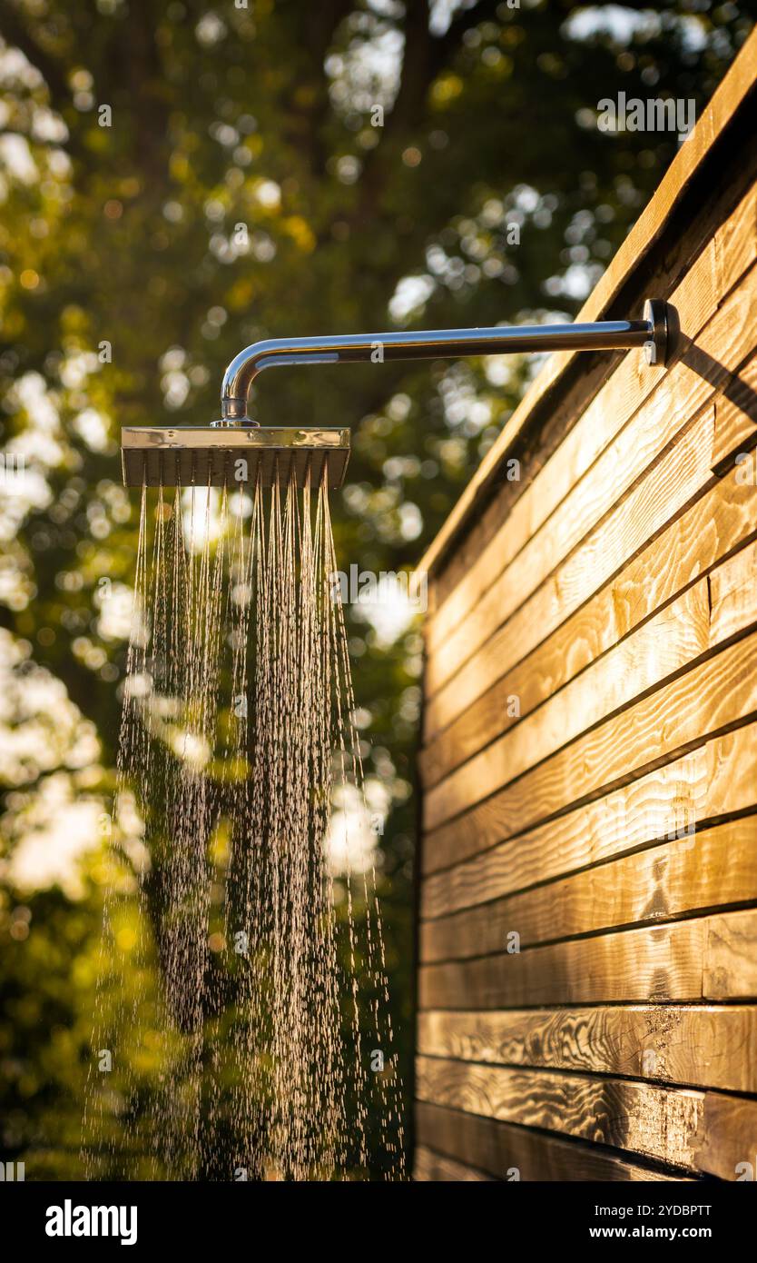 Outdoor shower with flowing water at sunset for showering before and ...