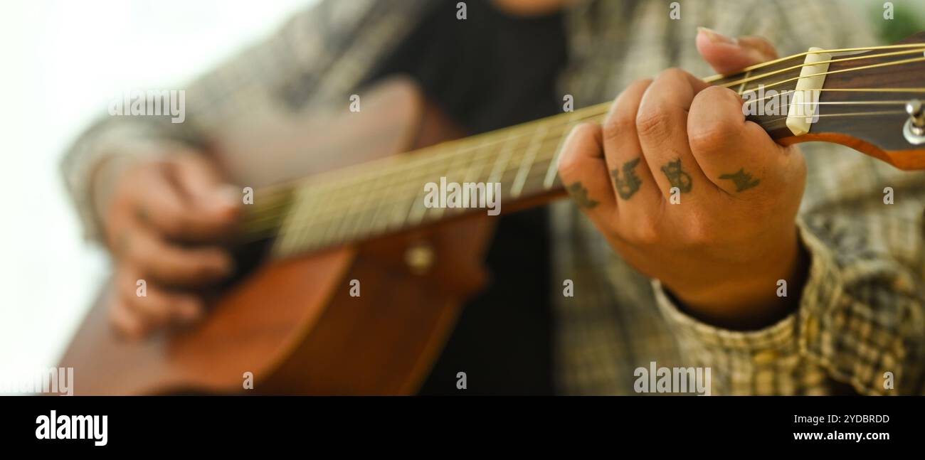Close up of man practicing acoustic guitar chords. Leisure activity and ...