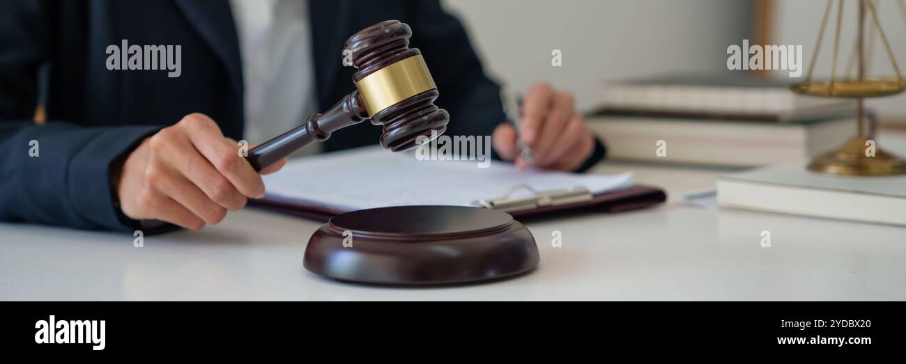 Labor law concept. Lawyer signing legal document with Judges gavel ...