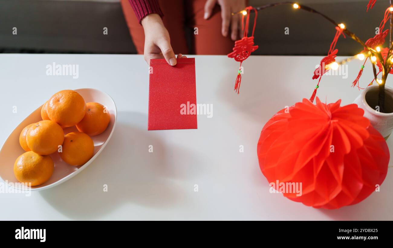Asian Woman giving red envelope for Lunar New Year celebrations. Hand ...