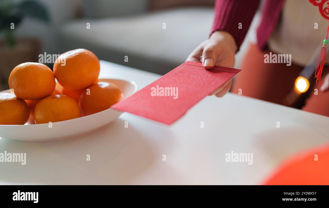 Asian Woman giving red envelope for Lunar New Year celebrations. Hand ...