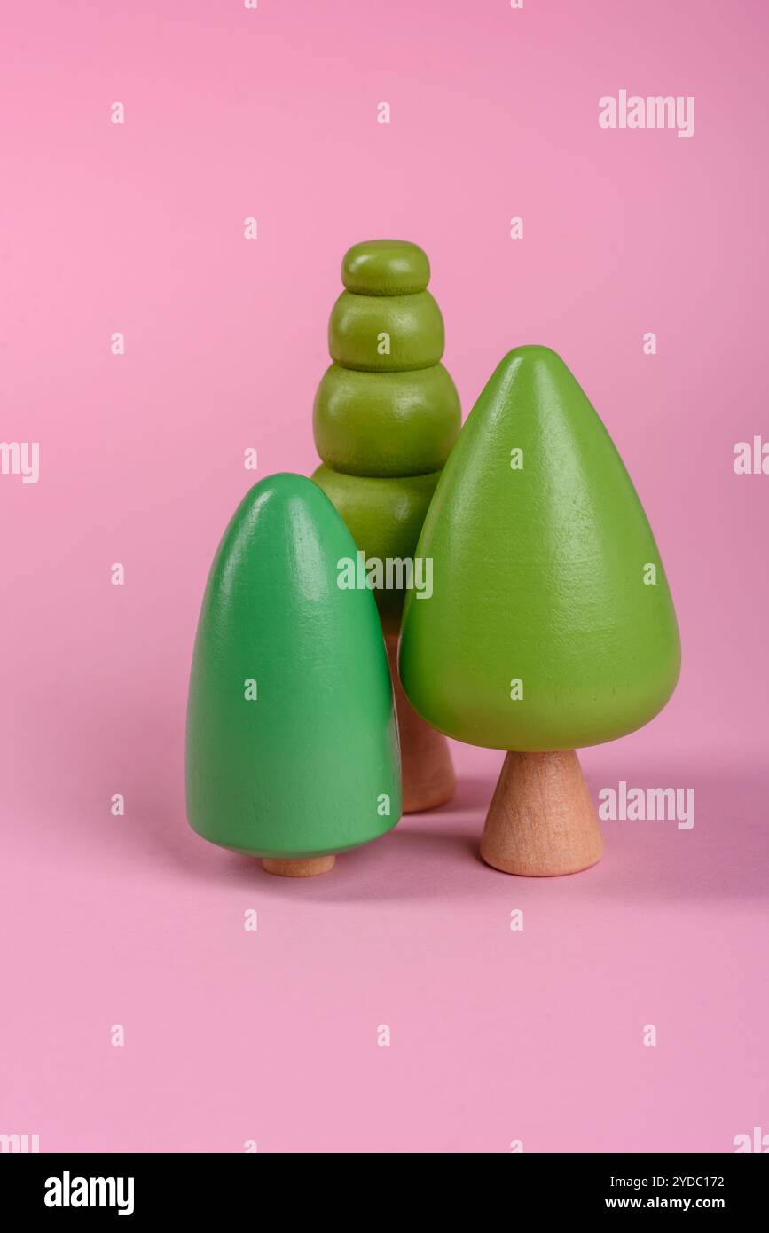 Wooden model of a tree with a green crown and trunk on a pink ...