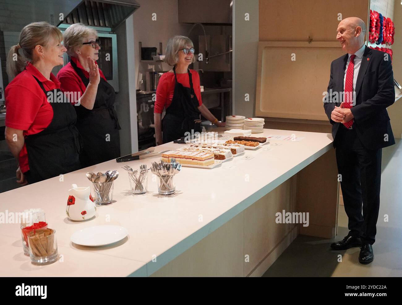 Defence Secretary John Healy is greeted by cafe volunteers (left to ...