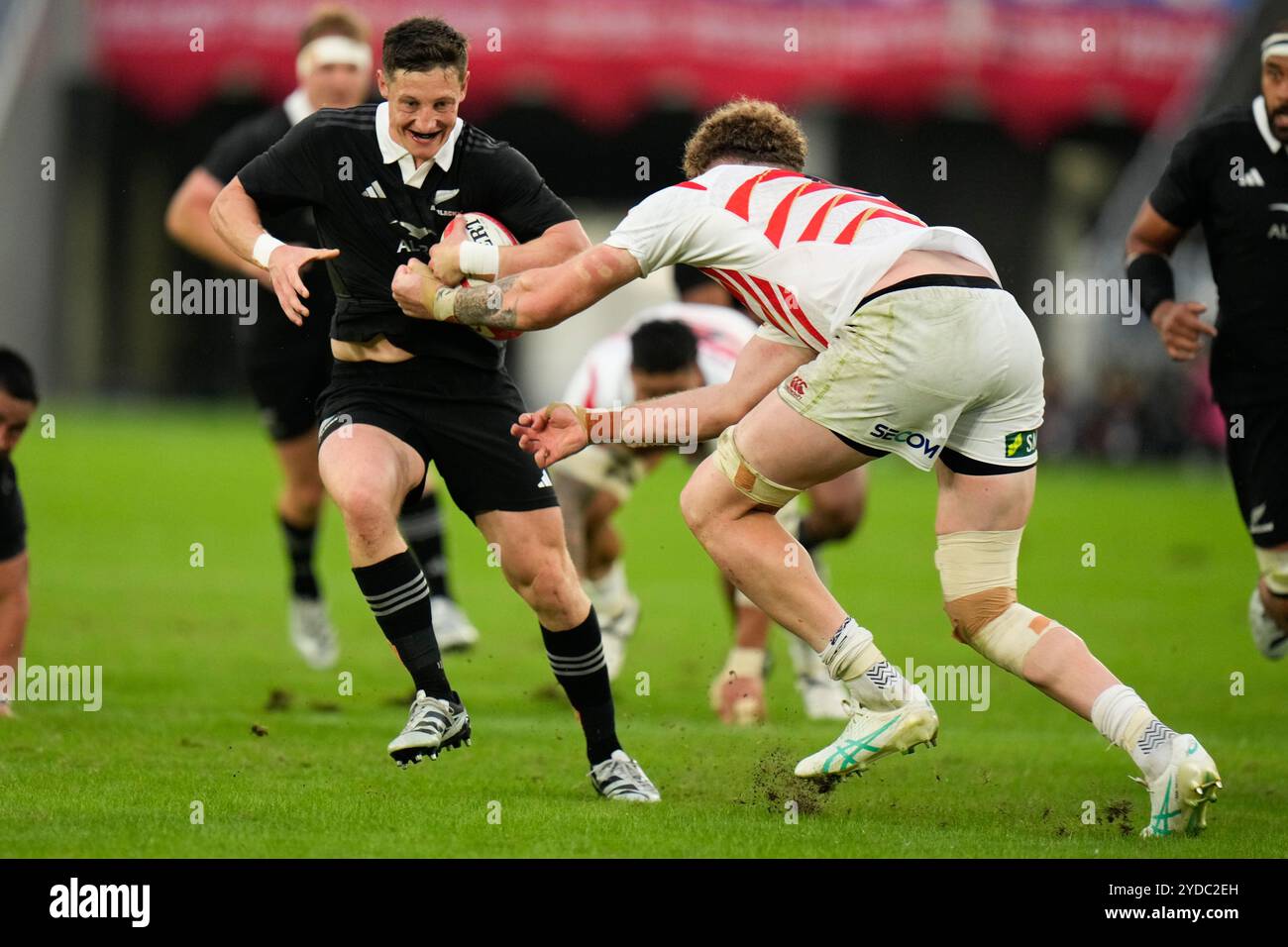 New Zealand's Cam Roigard breaks the tackle of Japan's Warner Dearns to ...