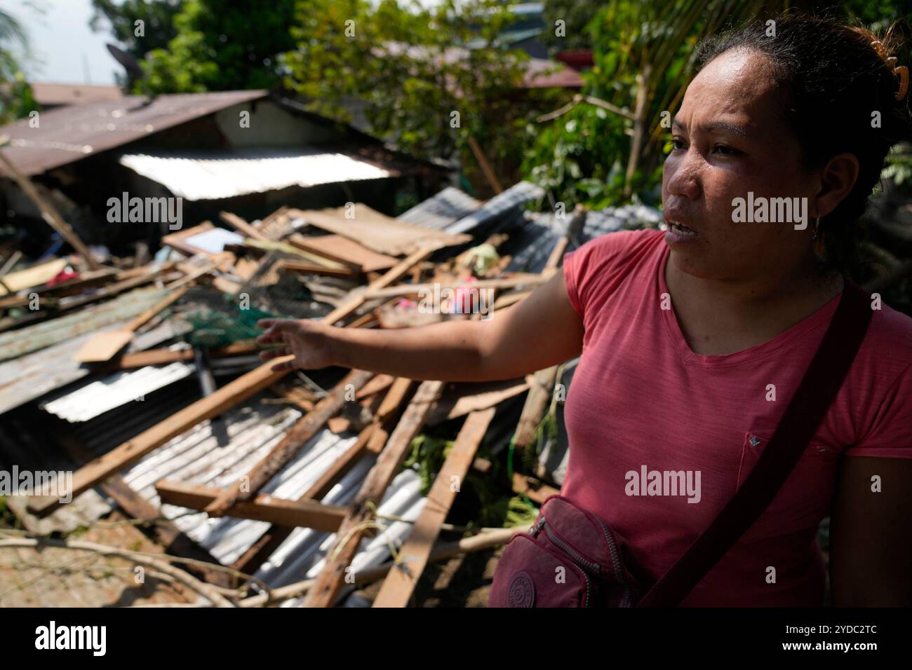 Doris Echin speaks near her damaged house after a landslide triggered ...