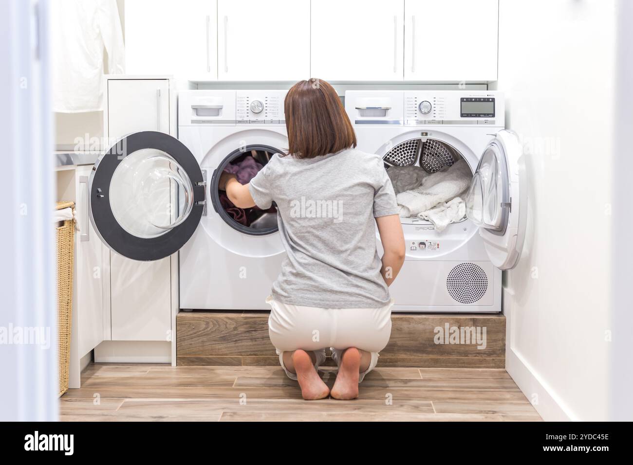 Woman putting clean laundry hi-res stock photography and images - Alamy