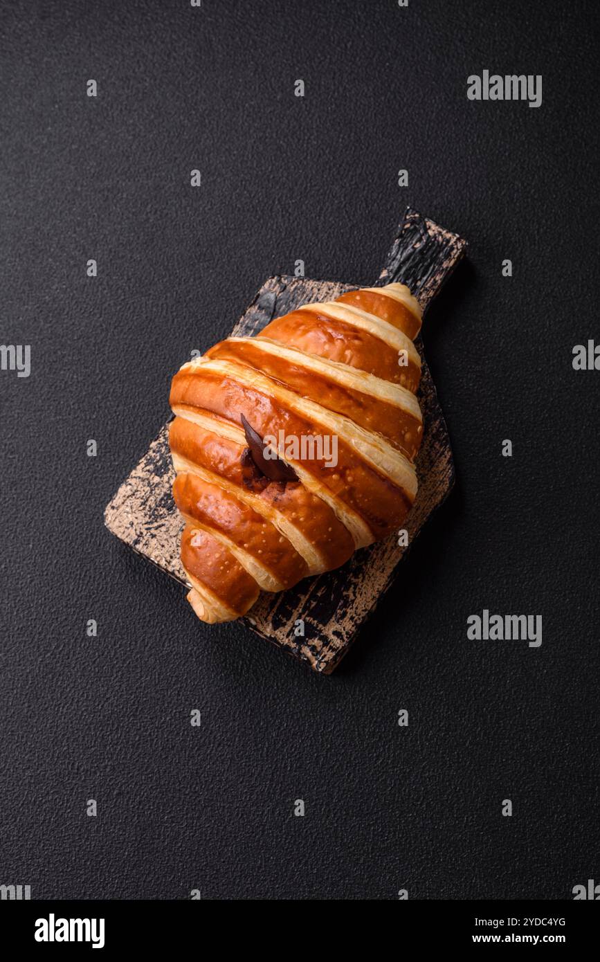 Delicious crispy sweet croissant cornet with chocolate on a dark ...
