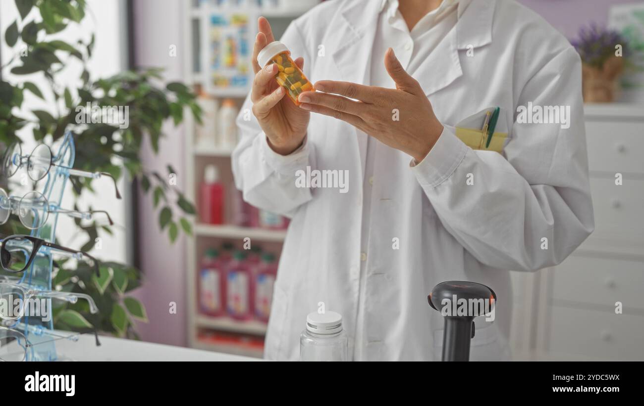 A female pharmacist examines a prescription bottle in a pharmacy ...