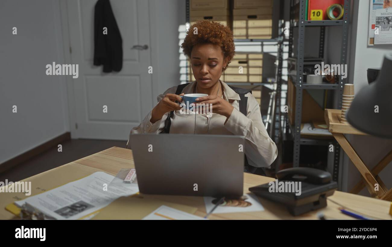 A focused black woman detective examines evidence while drinking coffee ...