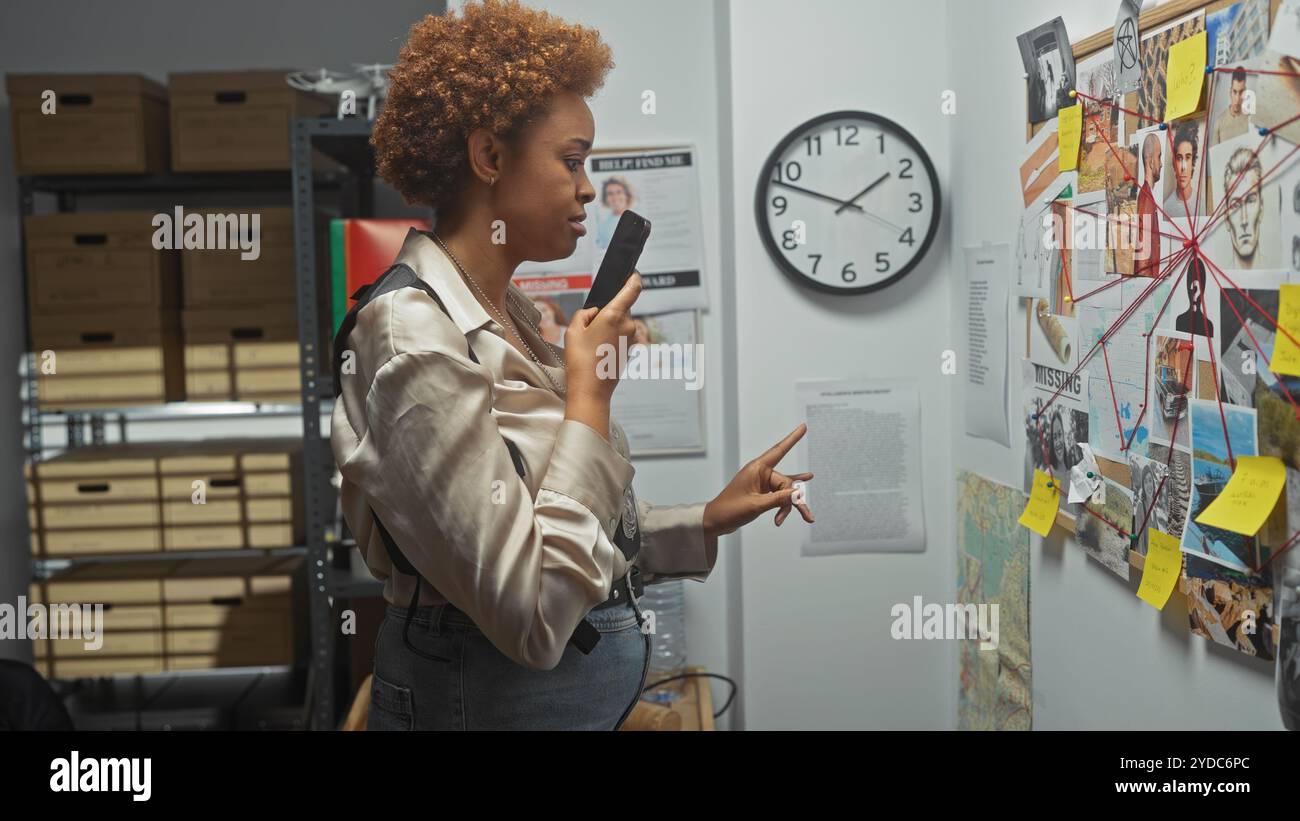 African american woman detective examines evidence in a police station ...