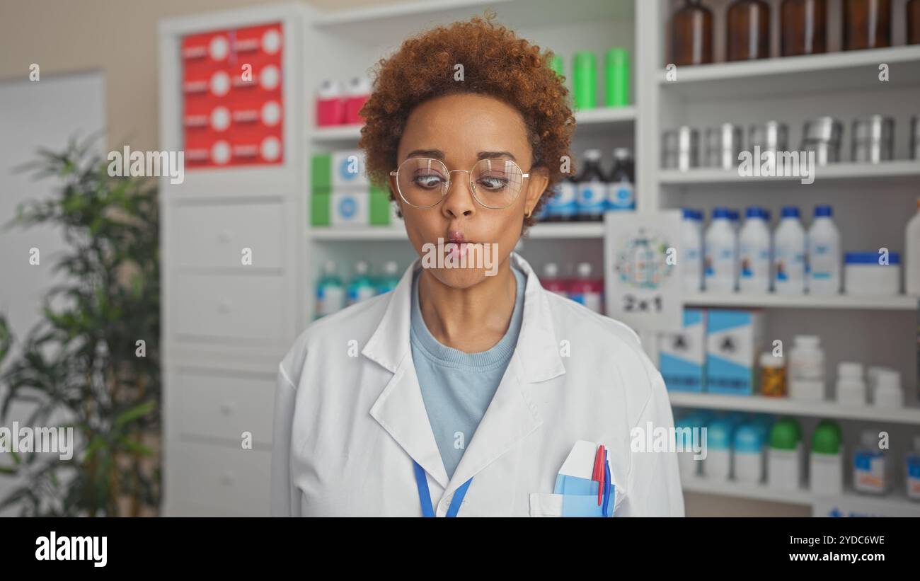 African american woman pharmacist in lab coat standing in a pharmacy ...