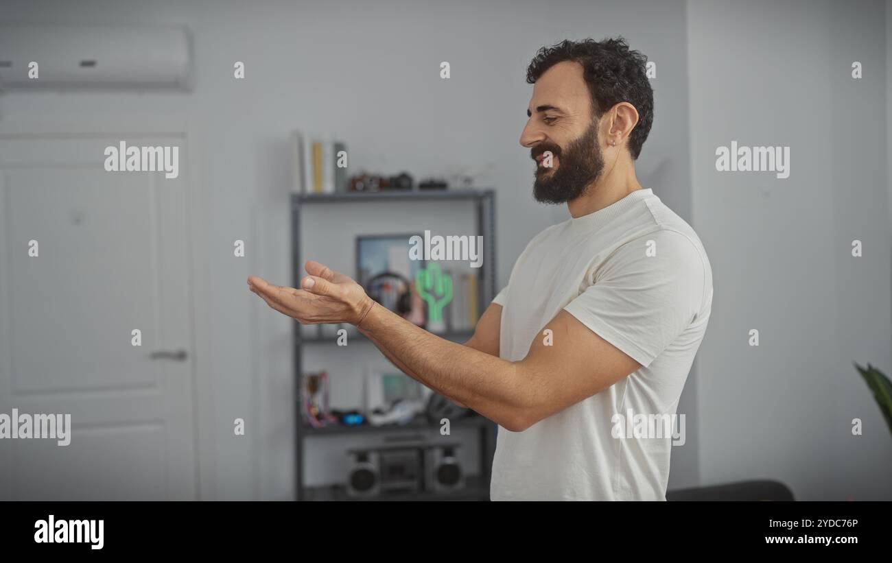 Bearded man in white presenting something invisible in a modern living ...