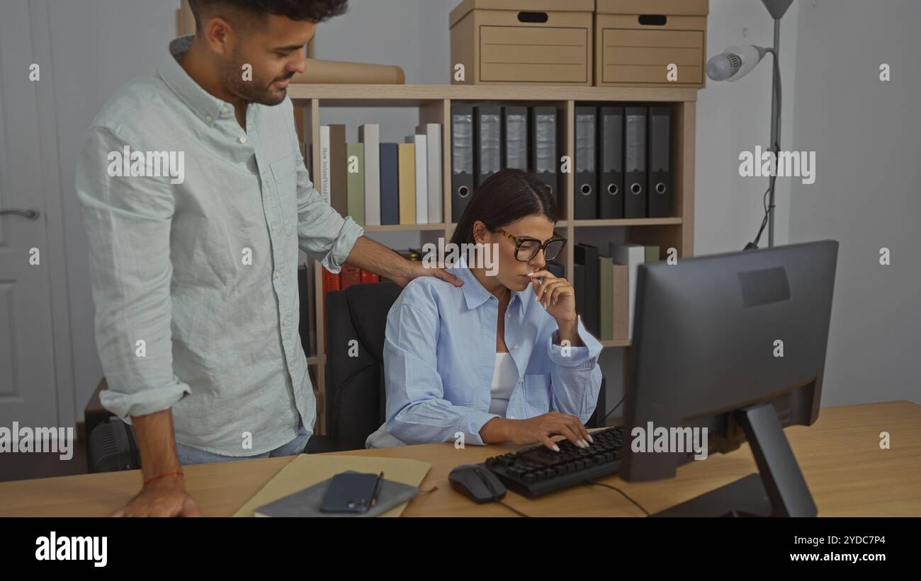 Man standing behind woman in office setting implies potential workplace harassment, with ...