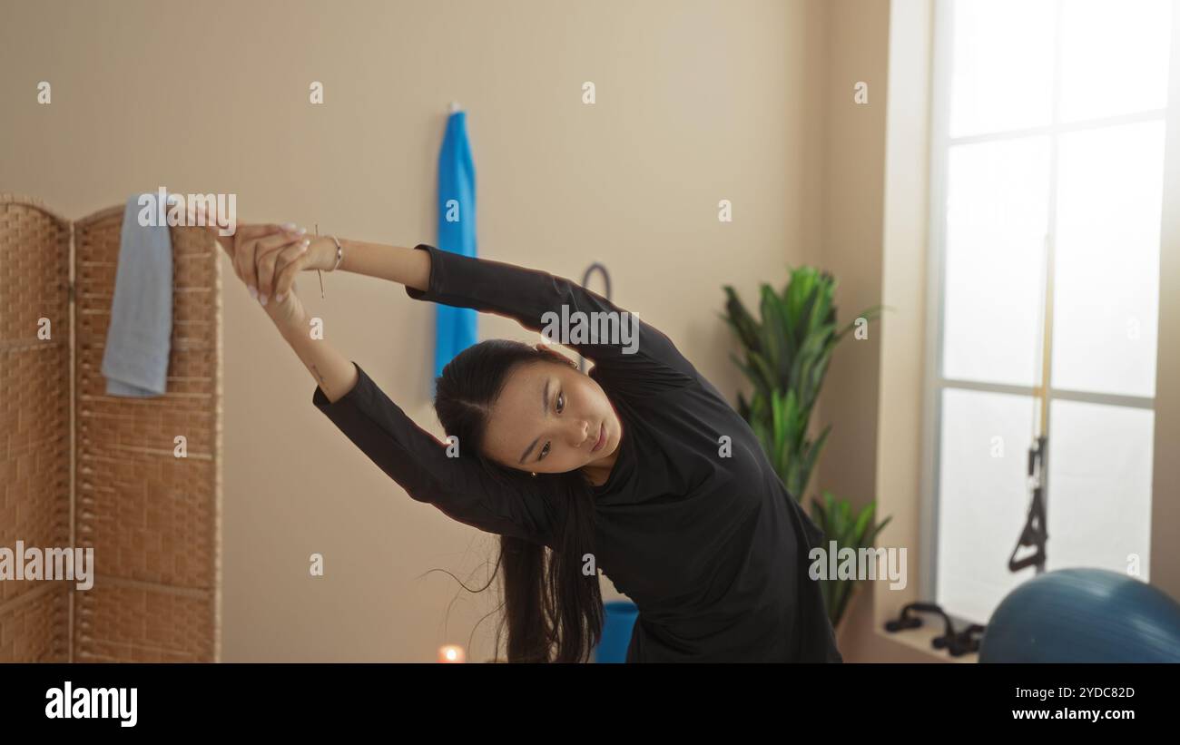 Woman stretching in an indoor sports center, showcasing athleticism and ...