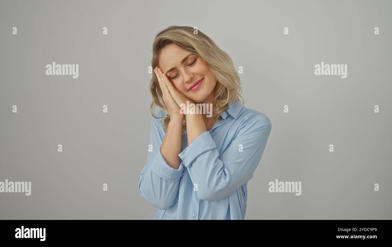 A beautiful, contented young woman with blonde hair, dressed in a blue ...