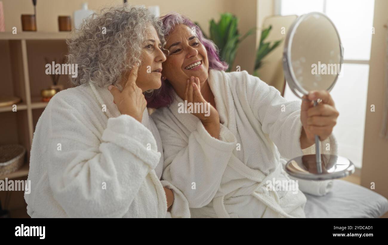 Middle-aged women friends in spa robes enjoying a beauty routine ...