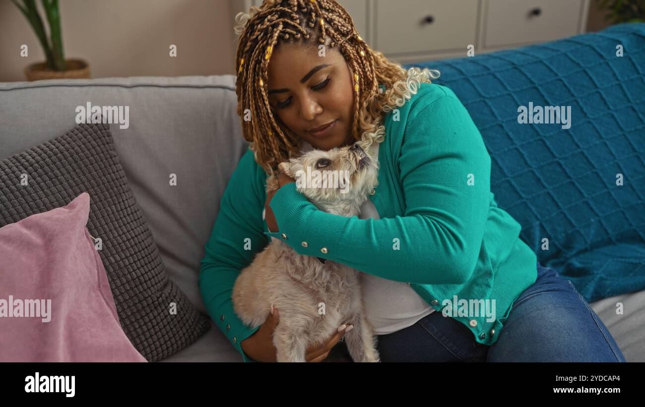 A young african american woman with braids lovingly holds her dog while ...