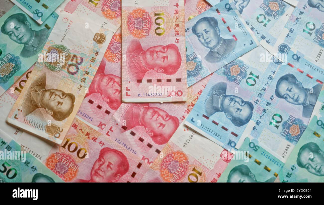 Chinese yuan banknotes scattered, showcasing various denominations and ...
