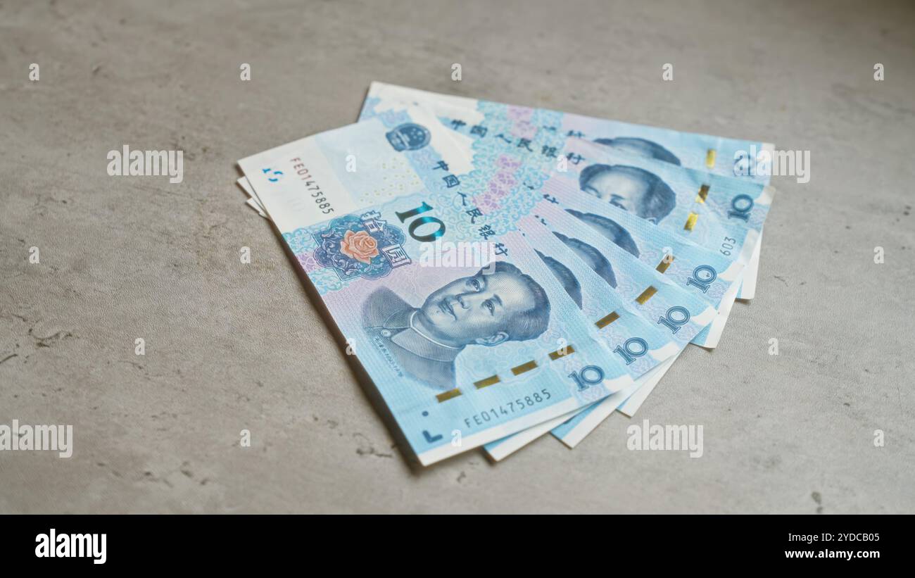 Chinese yuan banknotes arranged on a concrete surface, highlighting ...