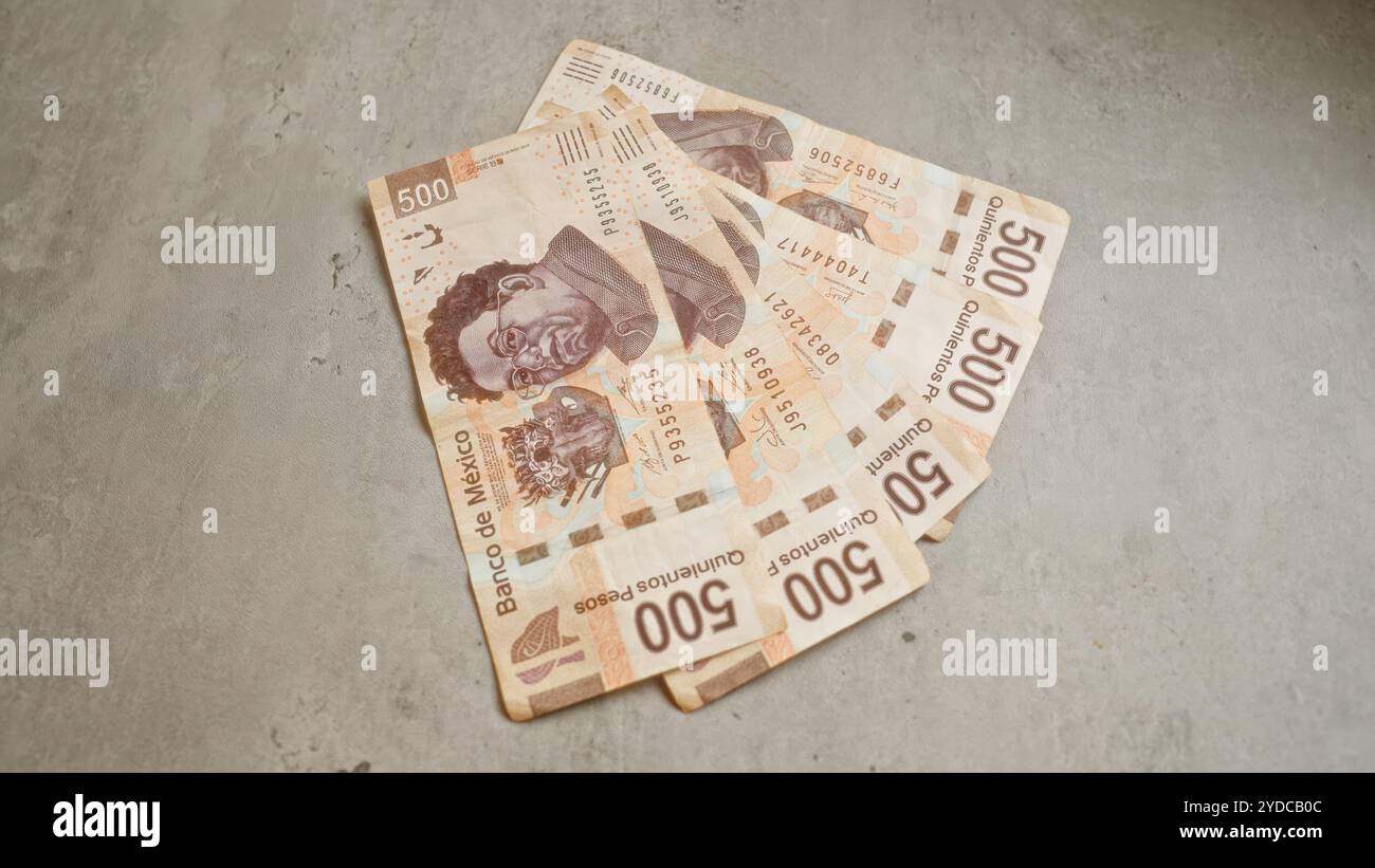 Mexican pesos banknotes spread out on a concrete surface highlight ...