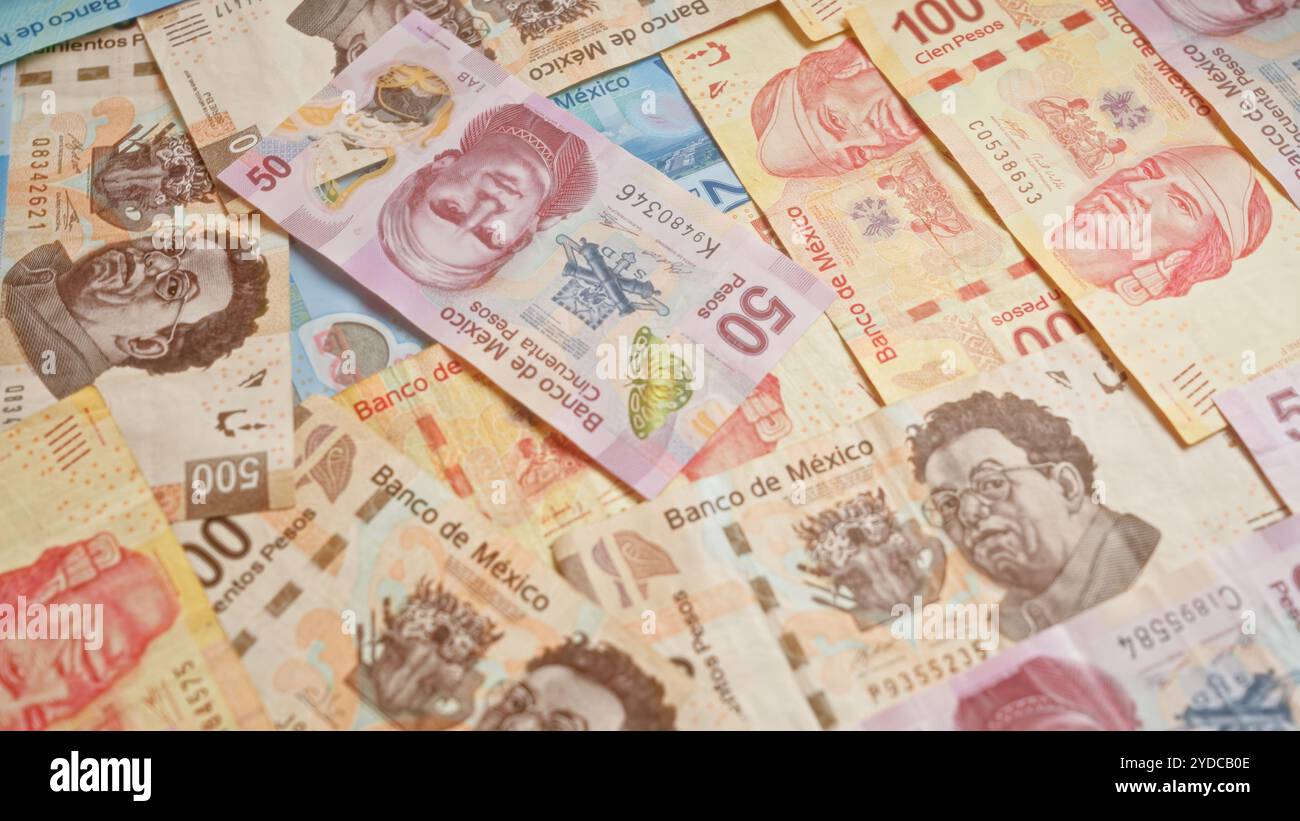 Colorful mexican banknotes of various denominations scattered in a pile ...
