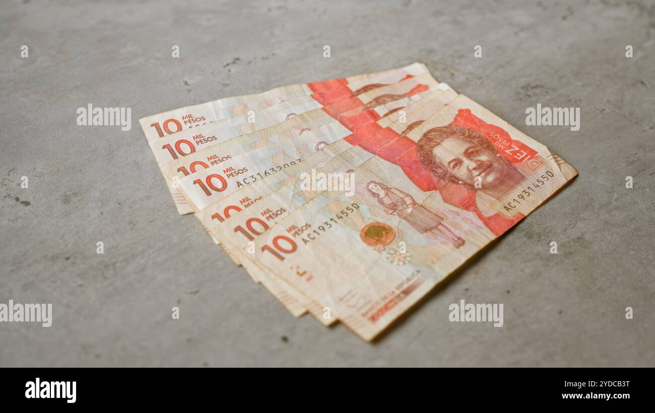 Colombian pesos displayed on a gray concrete surface, highlighting ...