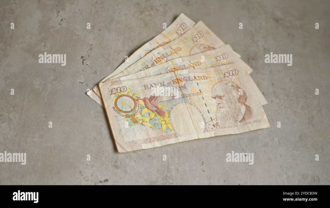 British banknotes featuring charles darwin are placed on a concrete ...