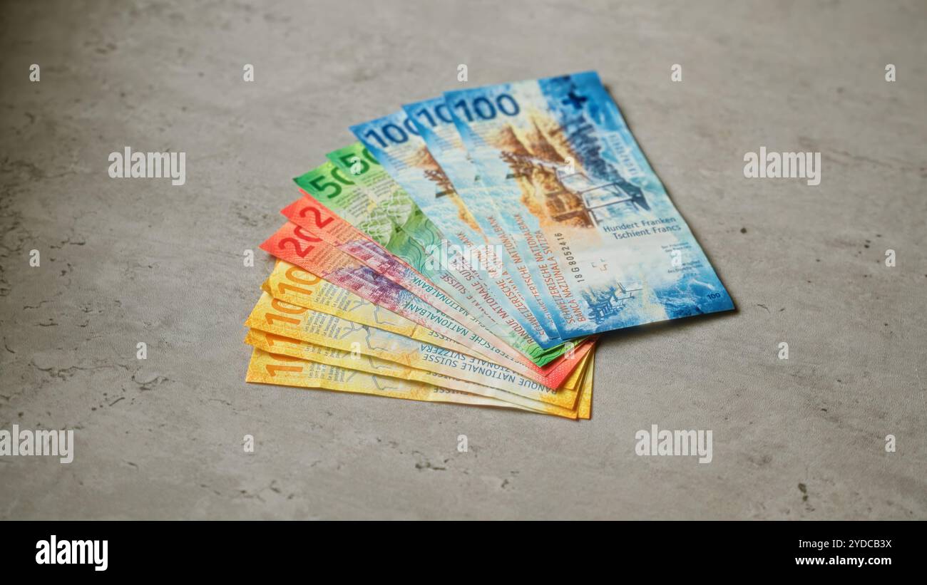 Swiss francs banknotes of various denominations arranged on a concrete ...