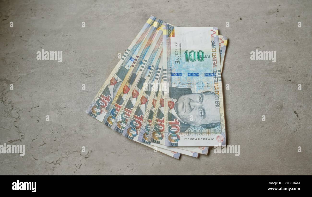 Peruvian banknotes in various denominations laid out on a concrete ...