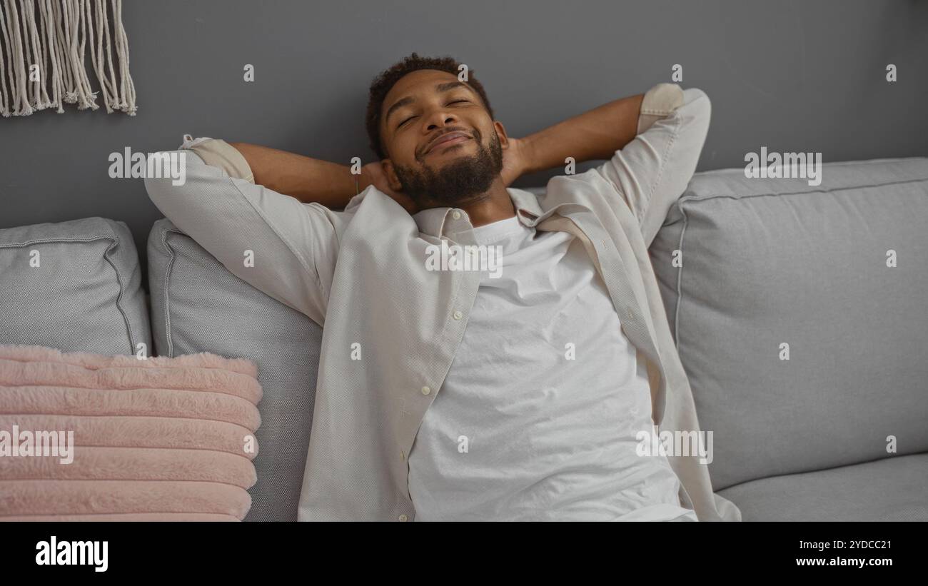 Handsome man relaxing indoors in a modern living room setting Stock ...