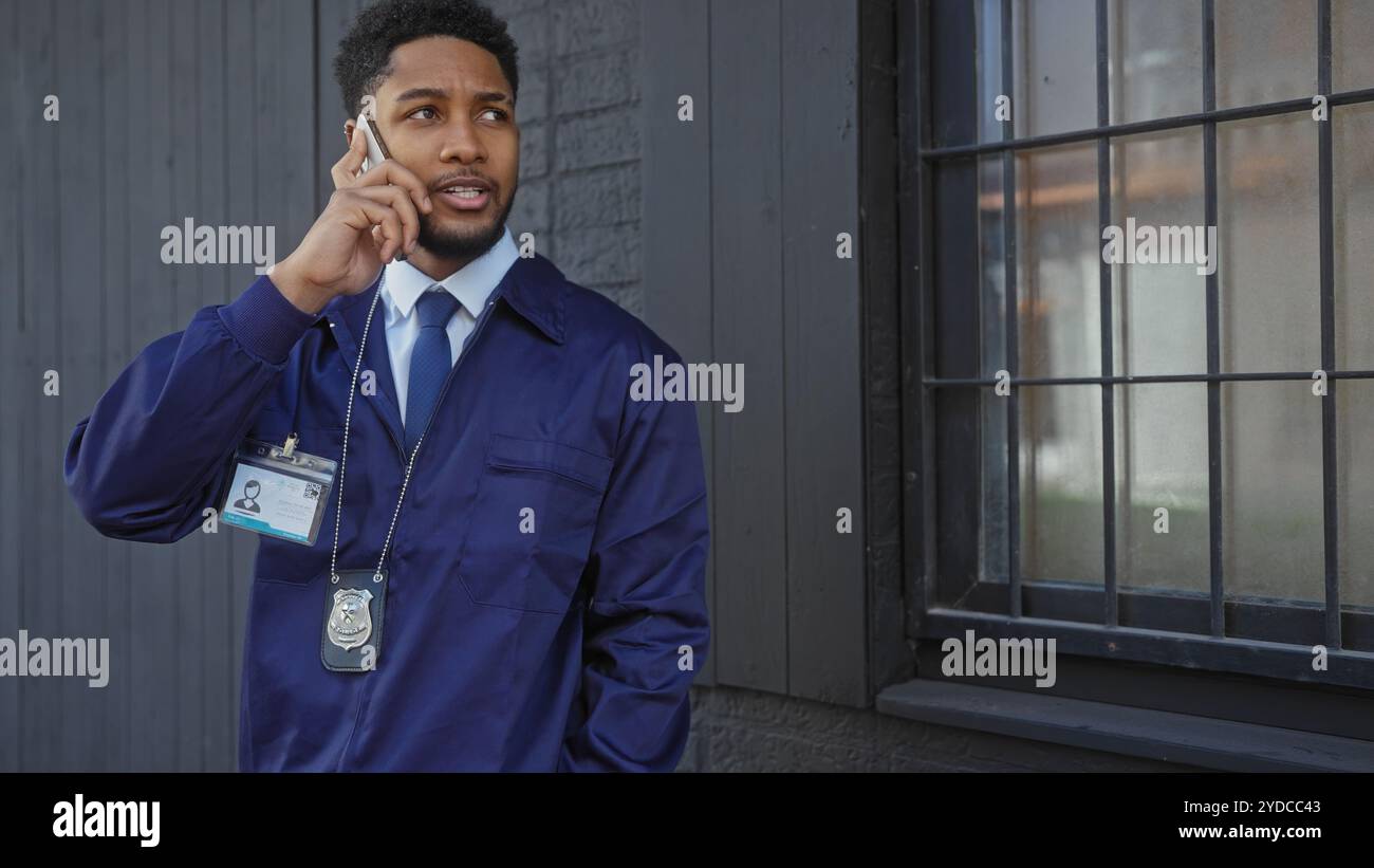 African american policeman talking on phone in urban setting Stock ...
