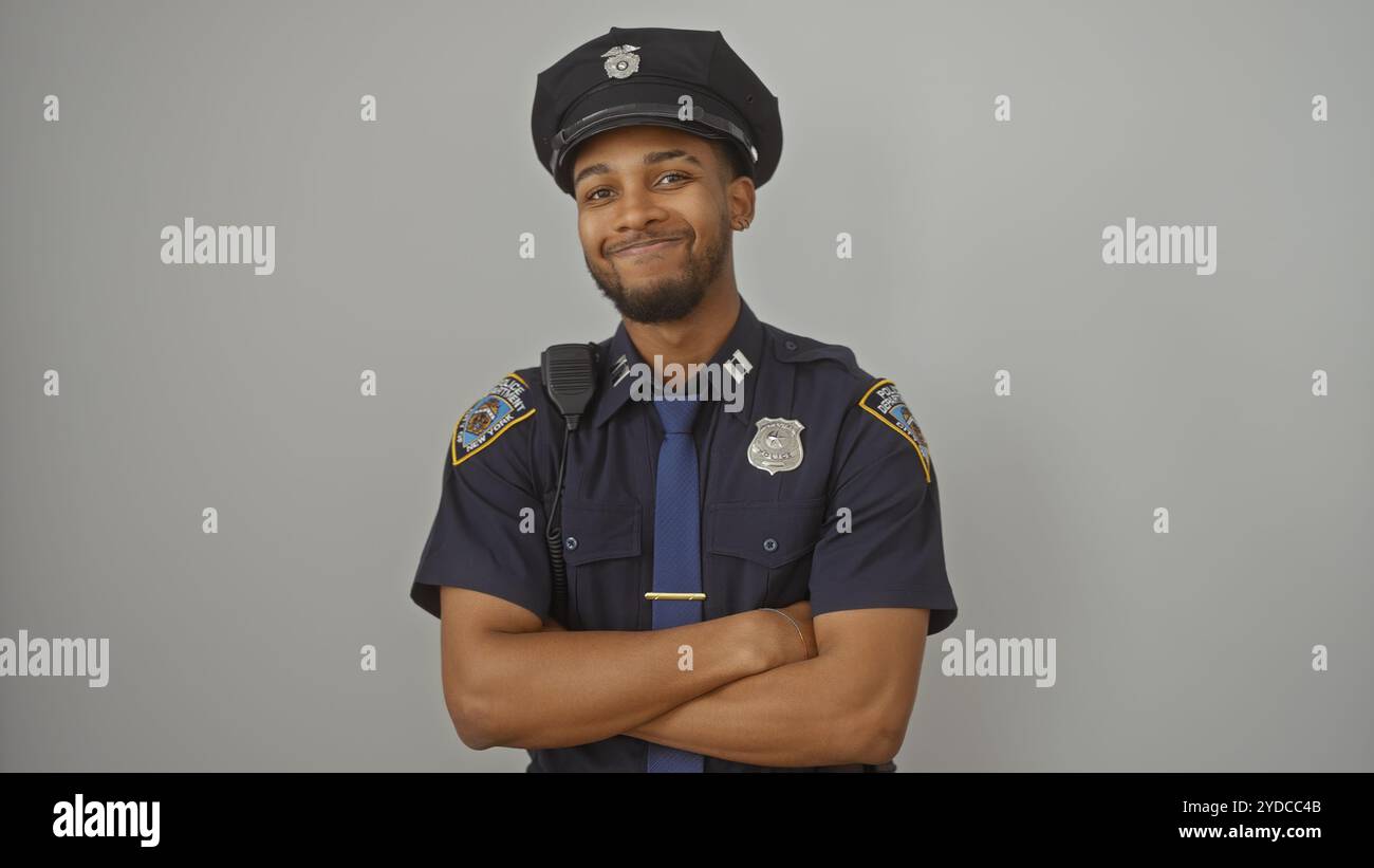 A confident african american police officer with crossed arms standing ...
