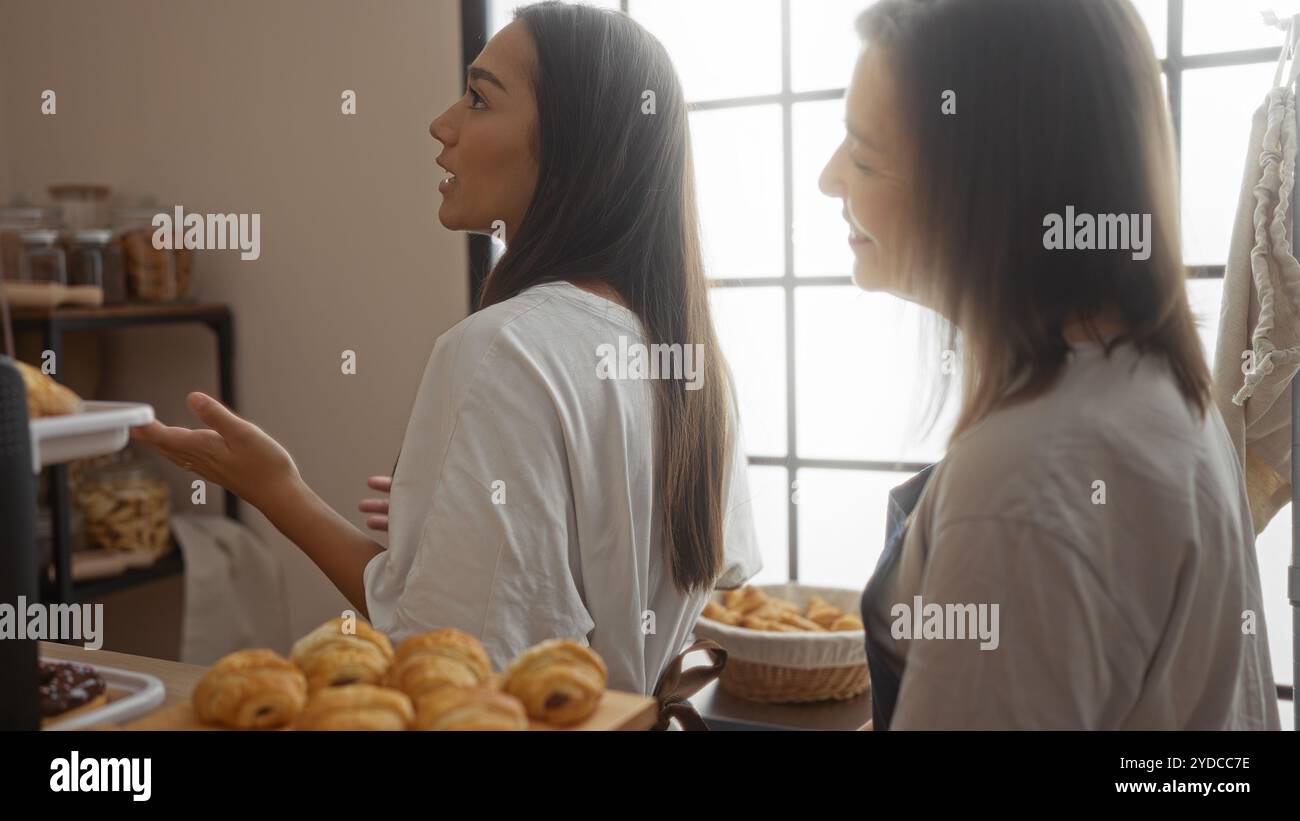 Two women bakers working together in a cozy bakery shop interior with ...