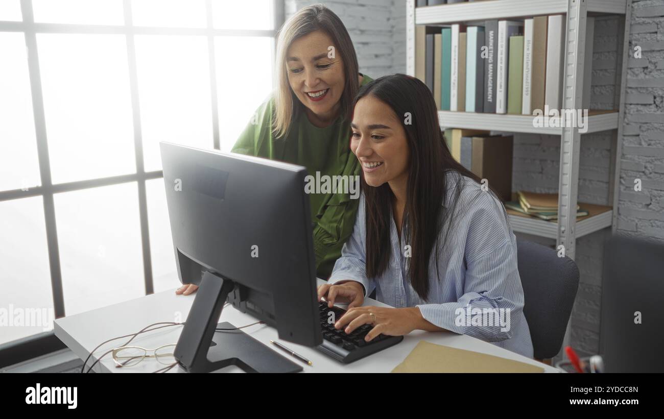 Women working together at a desk in a modern office with one woman ...