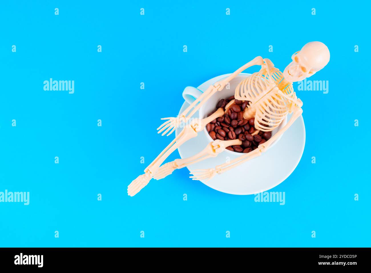 Top view of a skeleton model in coffee cup filled with roasted beans ...