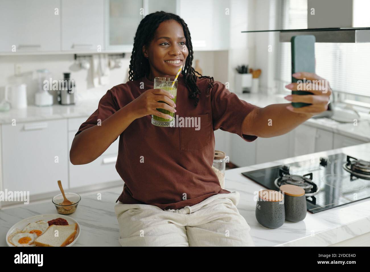 Young Woman Taking Selfie in Modern Kitchen Setting Stock Photo - Alamy
