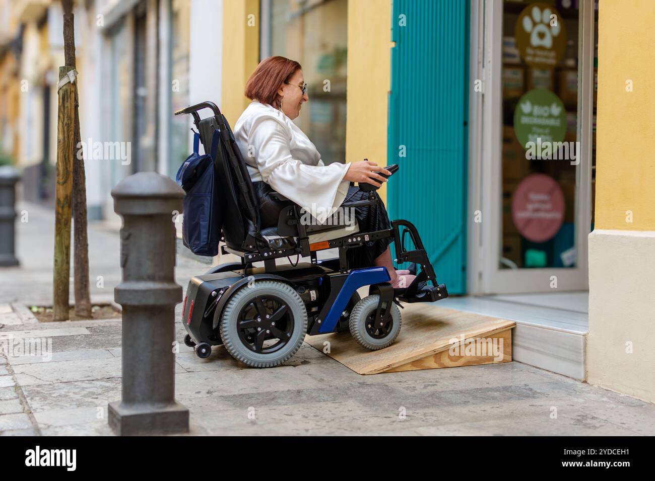 Wheelchair User Safely Using Ramp to Enter Urban Store Stock Photo - Alamy