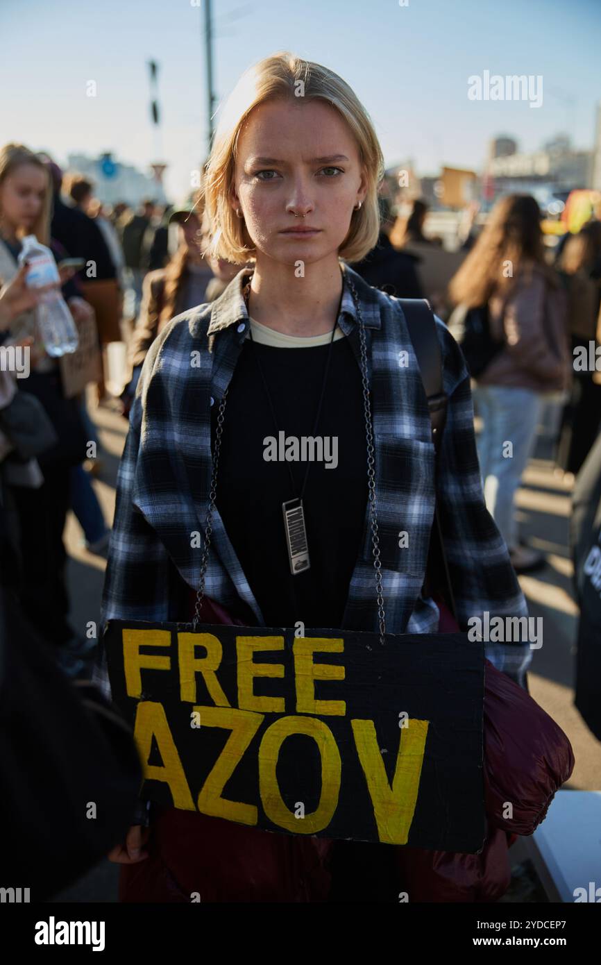 Young Ukrainian girl posing with a poster "Free Azov" on a public ...