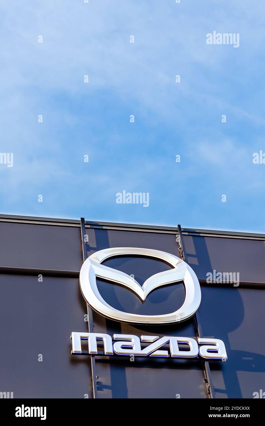 Mazda brand logo on bright blue sky background Stock Photo - Alamy